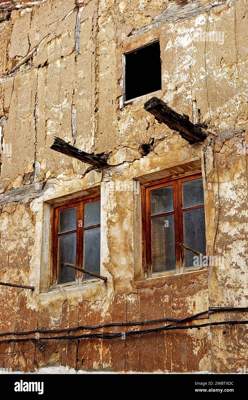 Abandoned structure featuring a dilapidated facade and two windows ...