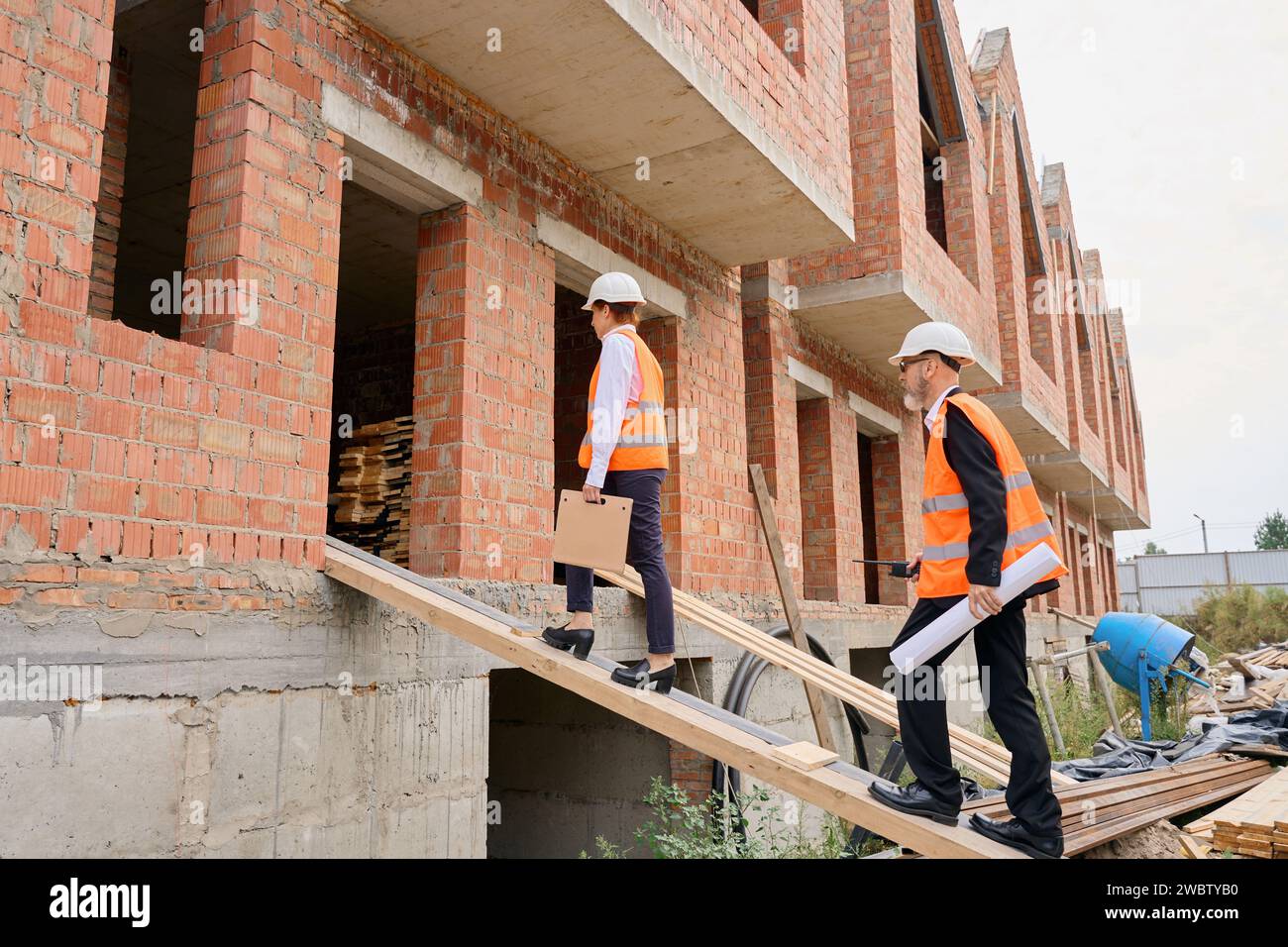 Construction manager and foreman entering into half-built house Stock ...