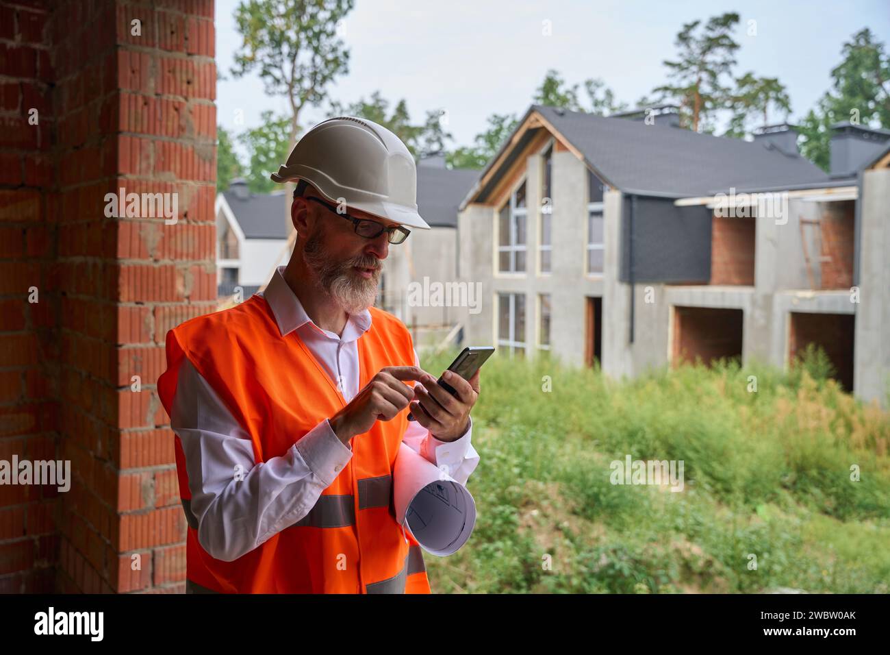 Focused construction worker using mobile phone on building site Stock ...