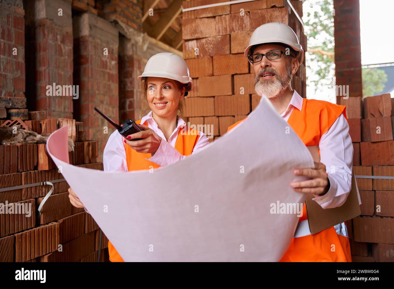 Construction specialists using blueprints during site inspection Stock Photo - Alamy