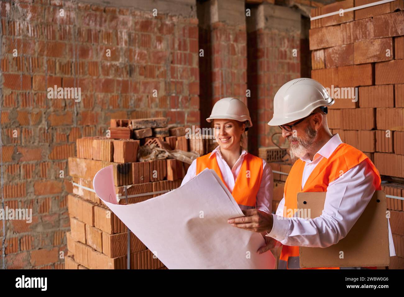 Foreman demonstrating blueprints to joyful building supervisor on site ... Foreman demonstrating blueprints to joyful building supervisor on site ...