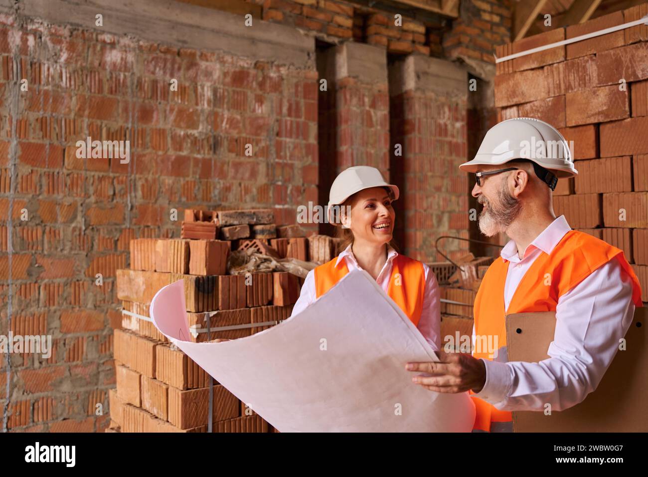 Contractor demonstrating architectural drawings to construction ...