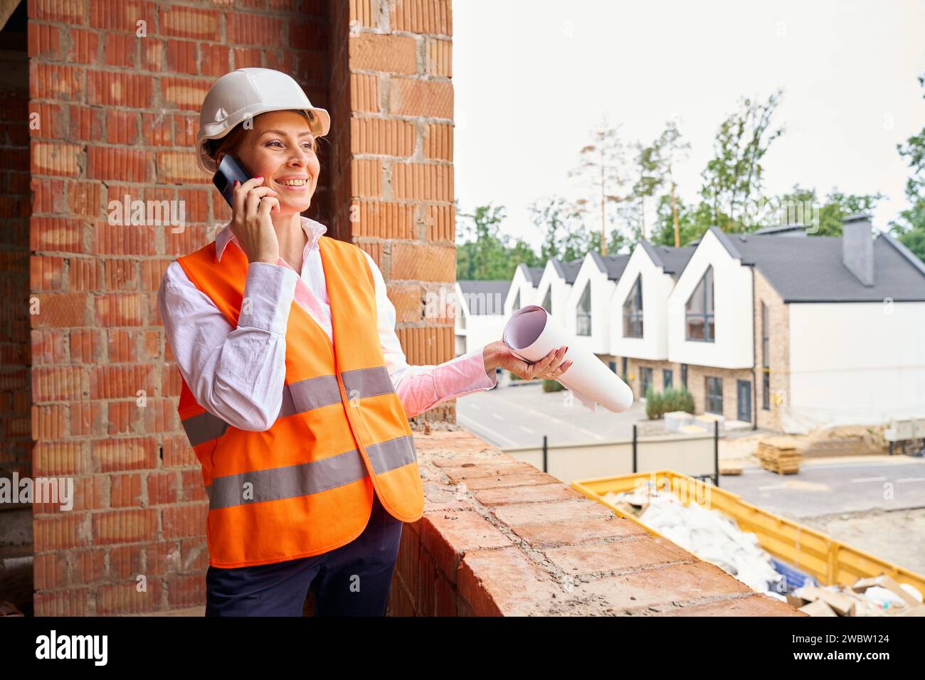 Construction supervisor talking on smartphone during development site ...