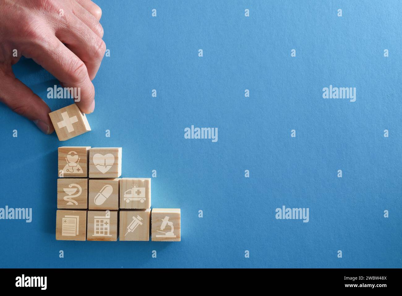 Medical care concept with hand stacking wooden cubes with symbols of ...