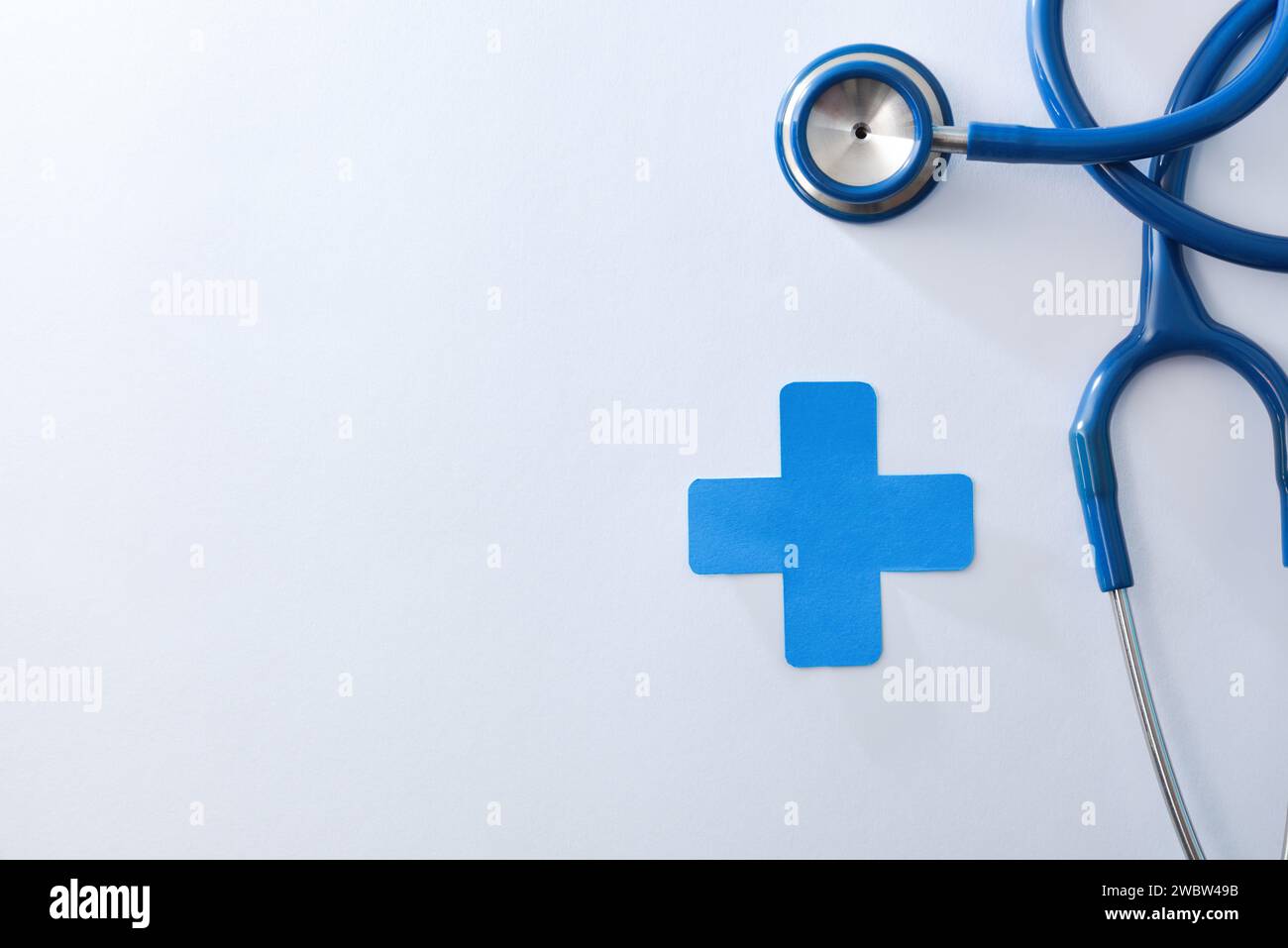 General medicine concept with stethoscope and blue paper cross-shaped ...