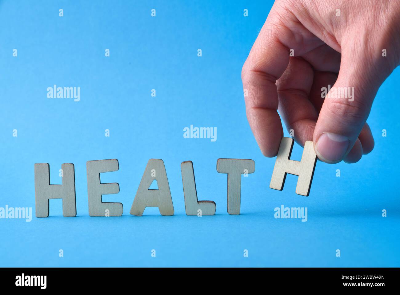 Health message with hand composing the word health with wooden letter ...