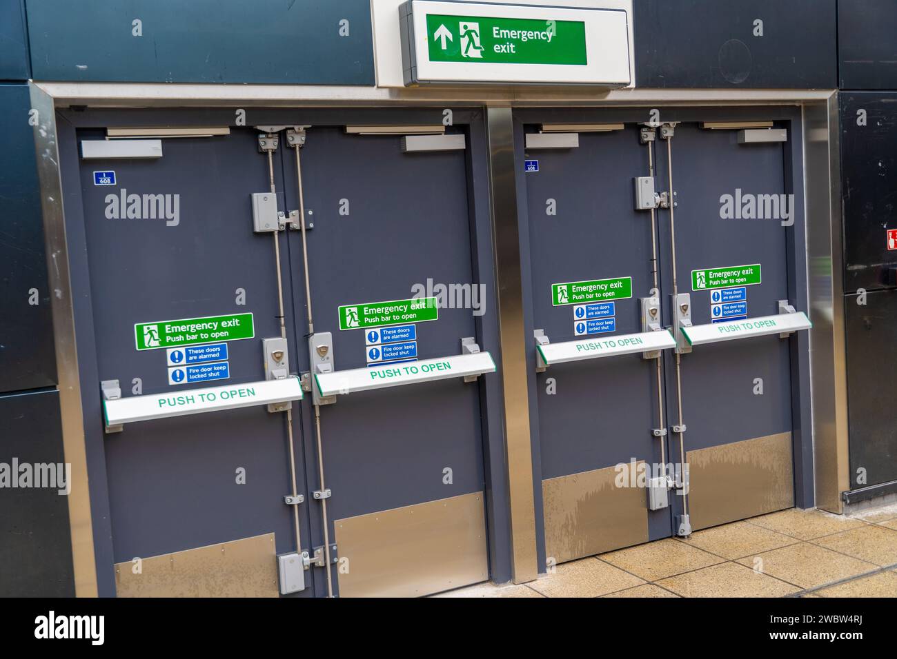 Emergency Exit sign ceiling hanging over 4 doors two sets of two Stock ...
