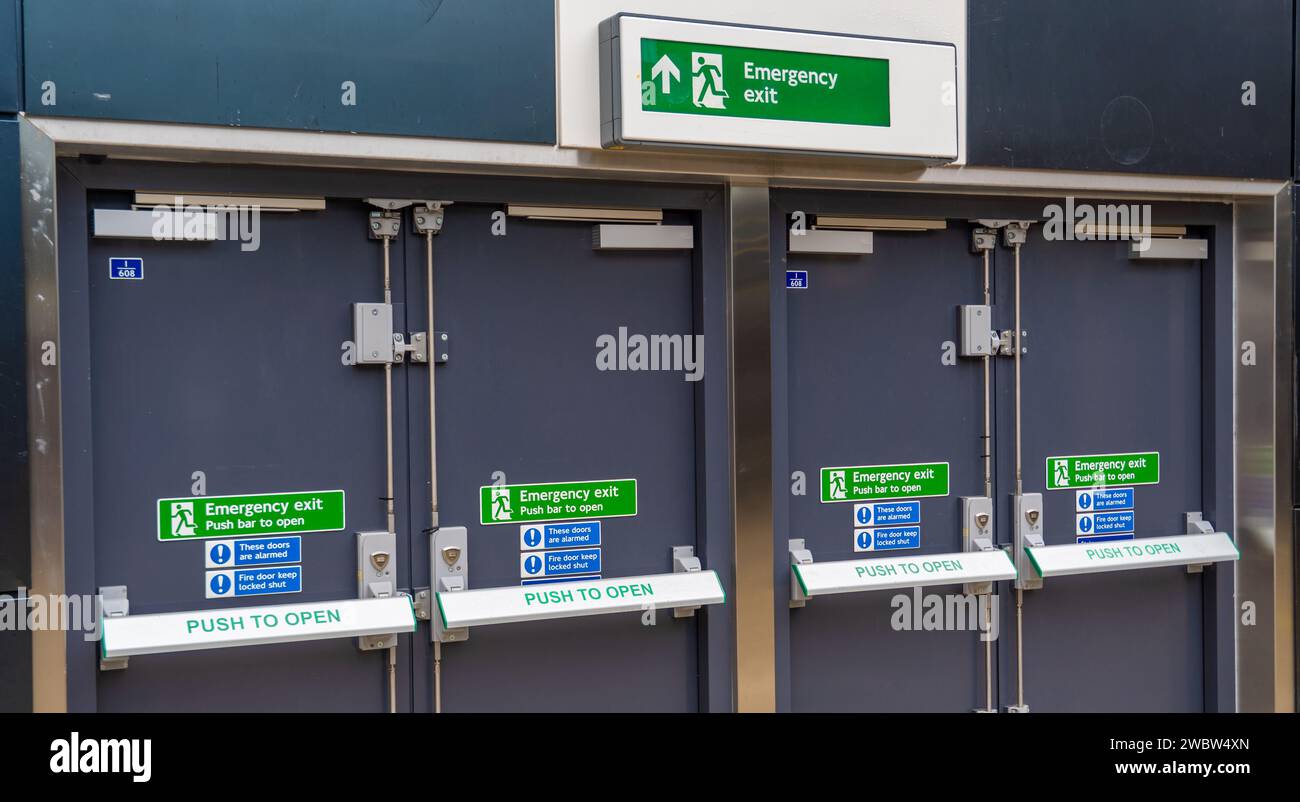 Emergency Exit sign ceiling hanging over 4 doors two sets of two Stock ...