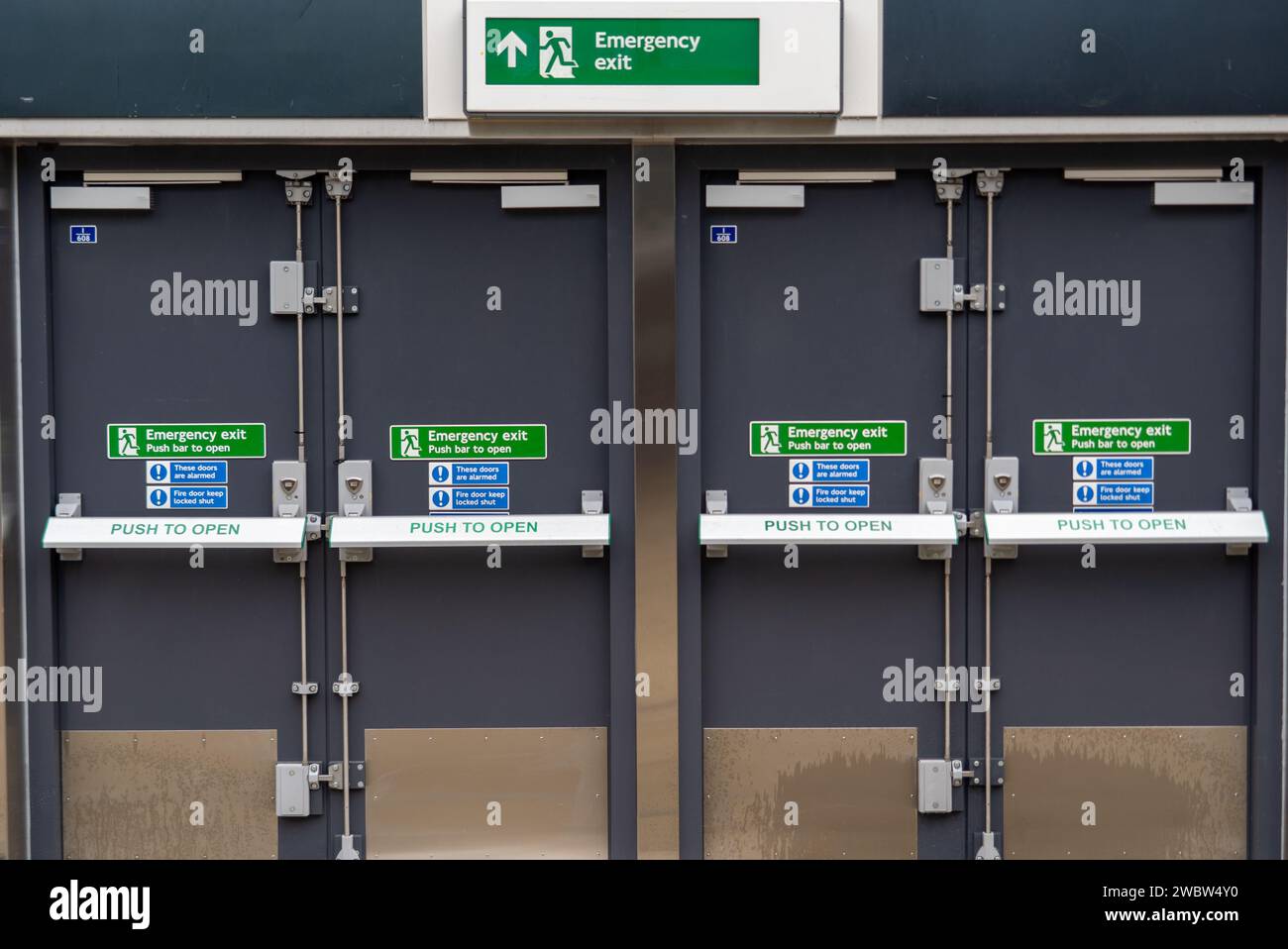 Emergency Exit sign ceiling hanging over 4 doors two sets of two Stock ...