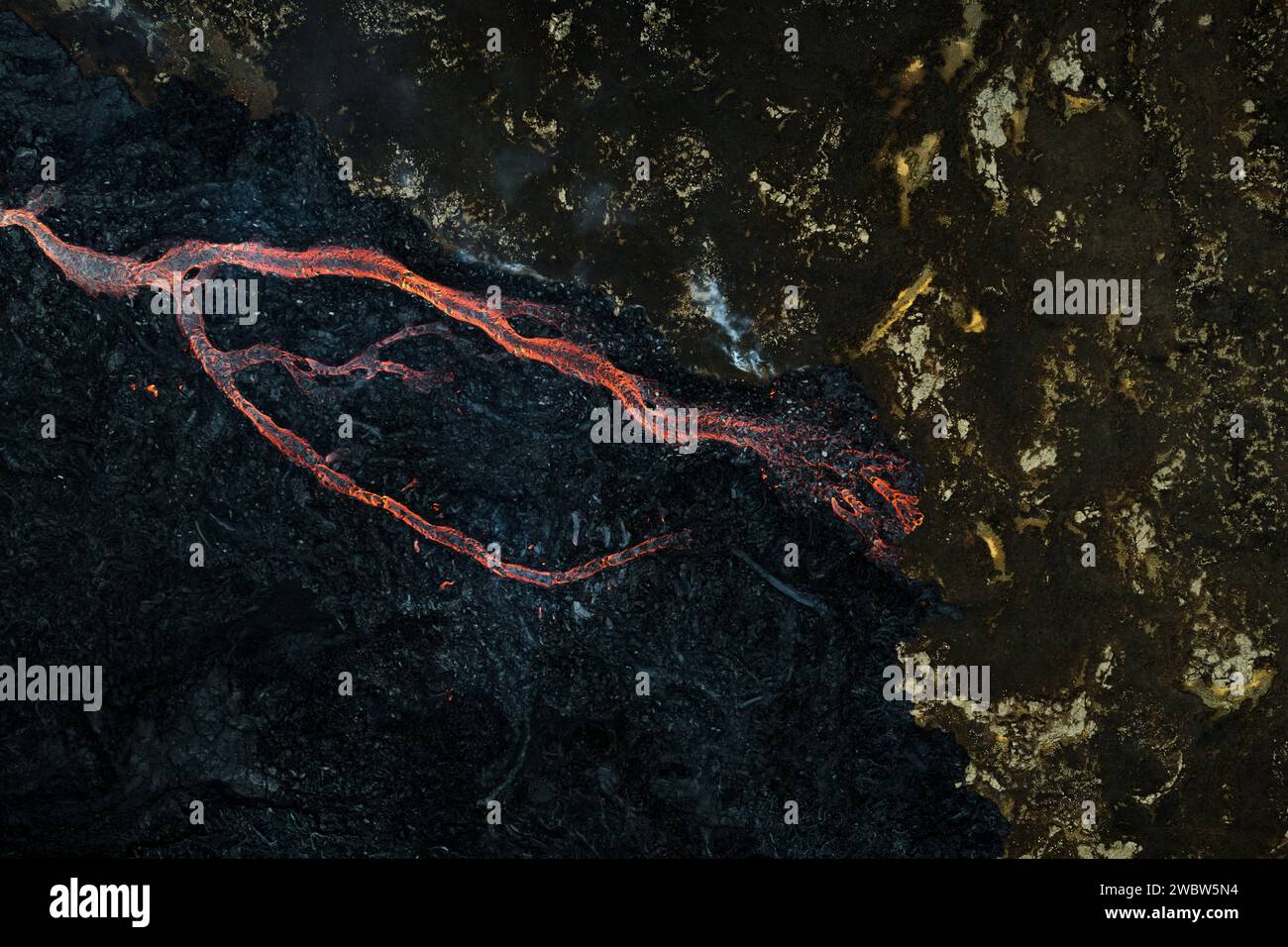 Streams of red hot lava flowing during a volcano eruption, toxic smoke ...