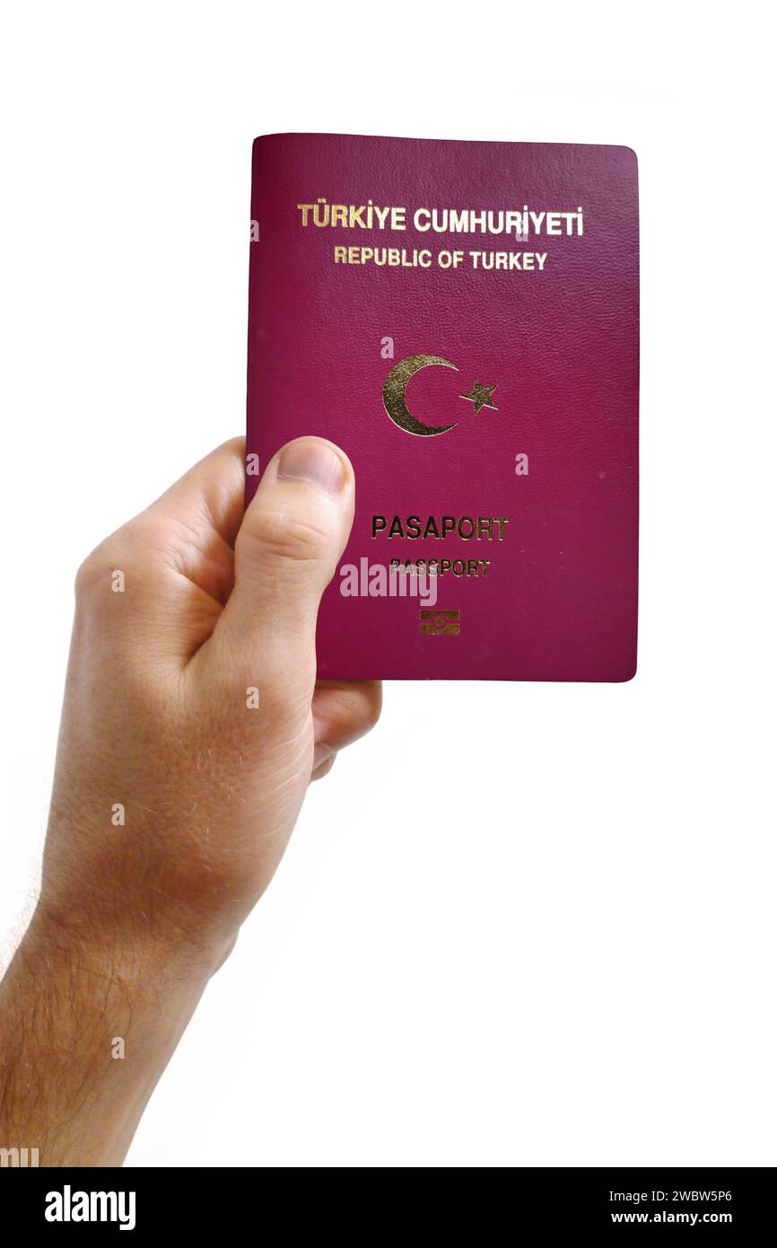 Close-up on a man's hand holding a Turkish passport against a white ...