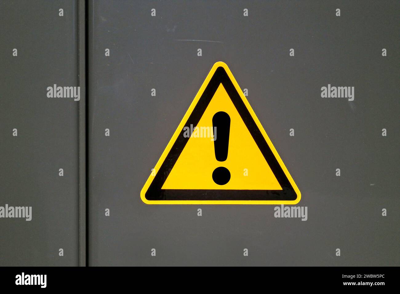 Yellow caution sign on a metal door warning about "Potential danger ...