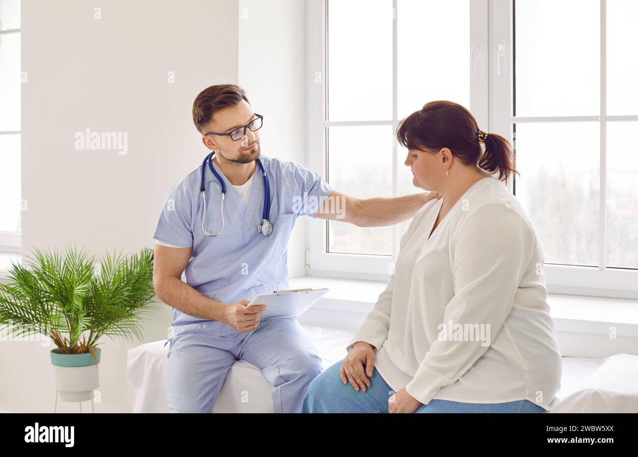 Doctor supporting sad fat woman, holding hand on her shoulder and ...