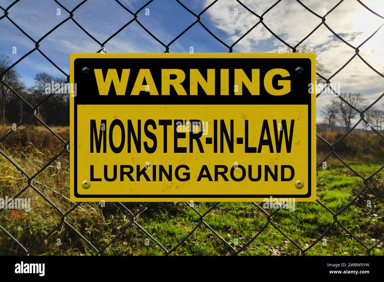 Black and yellow warning sign on a fence with the message "Warning ...