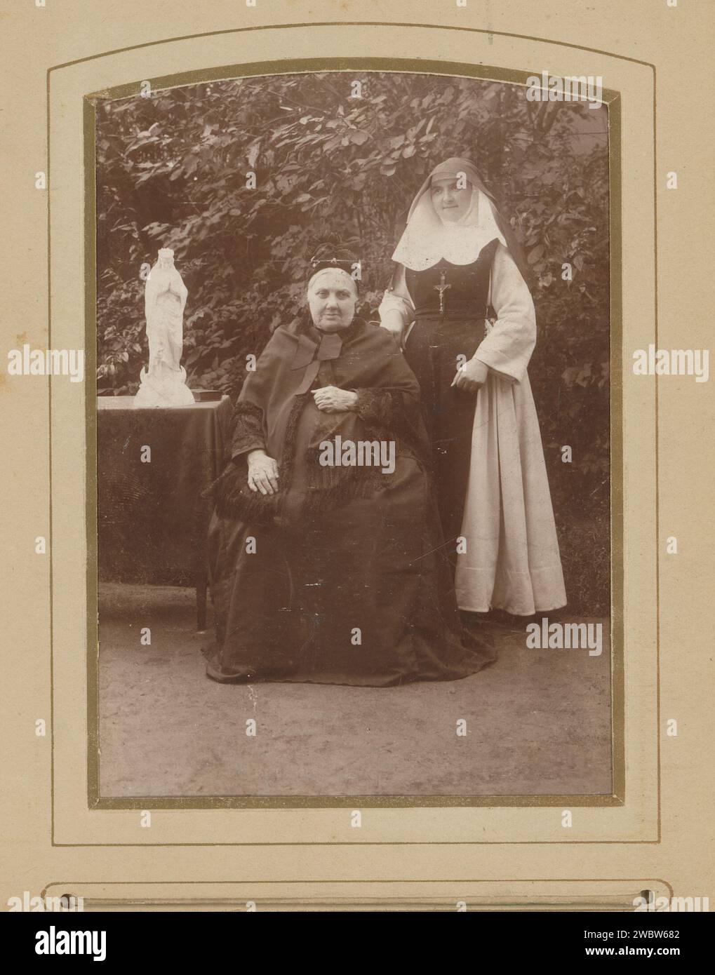 Portrait of a sitting woman dressed in black and a standing nun ...