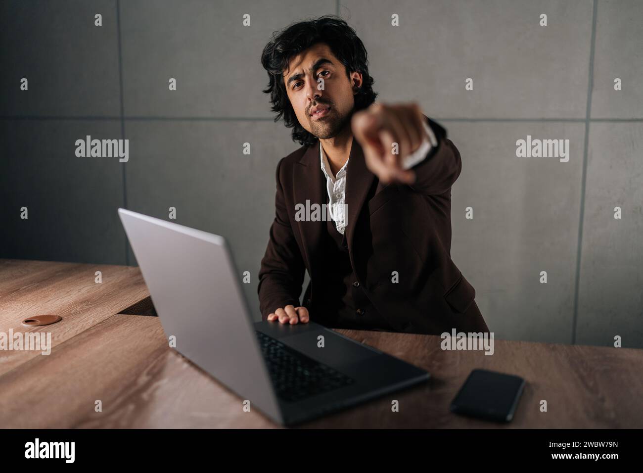 Portrait of serious successful businessman in suit looking at camera ...
