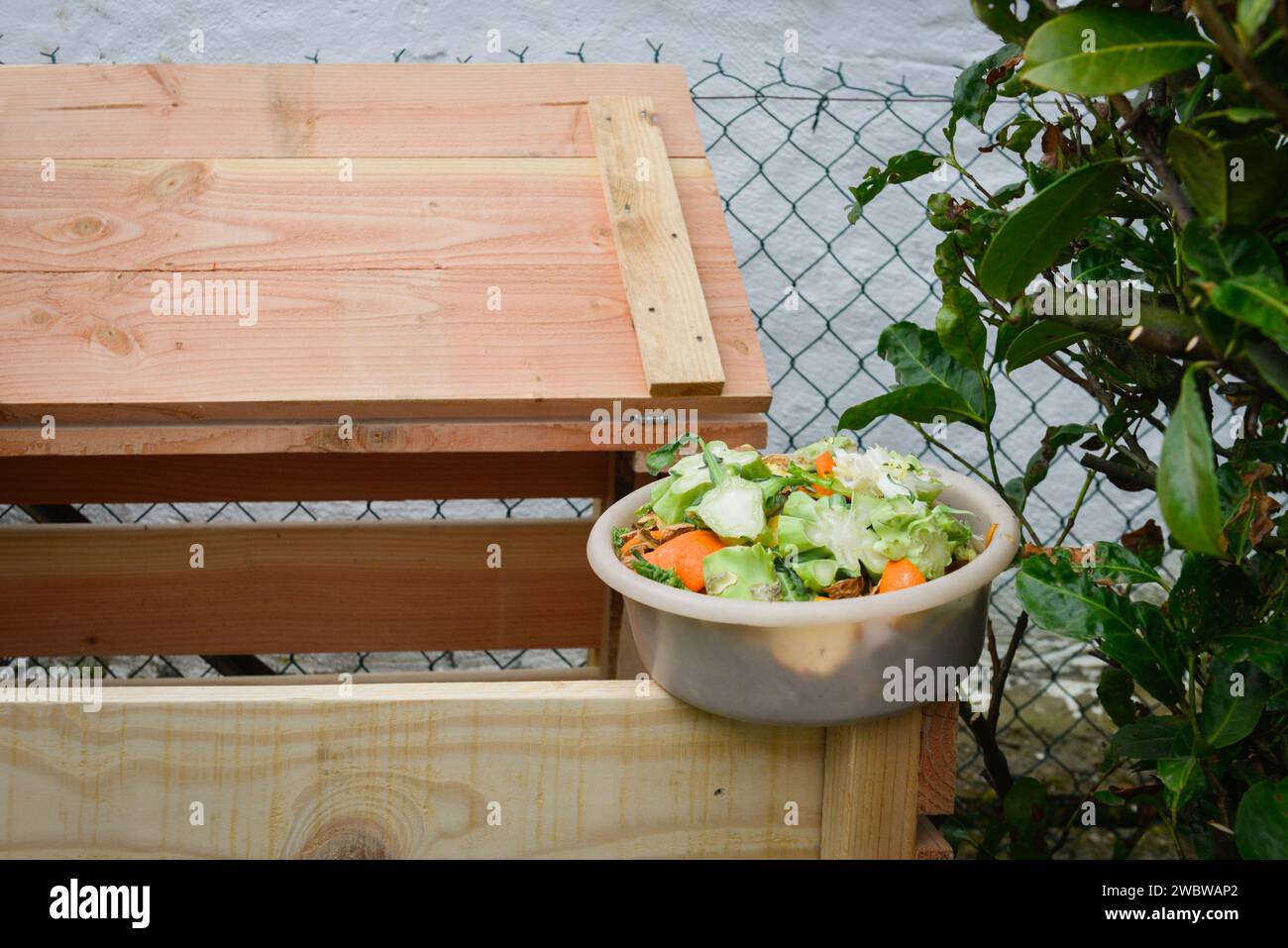 Peelings and vegetable waste in a basin on an empty new wooden ...