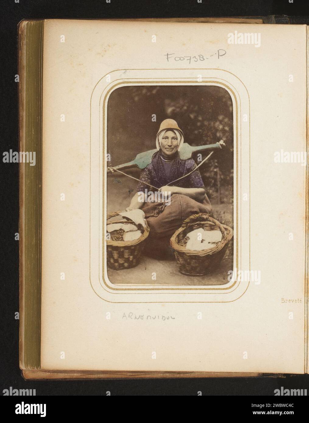 Portrait of a woman with yoke and baskets with presumably hats, in ...