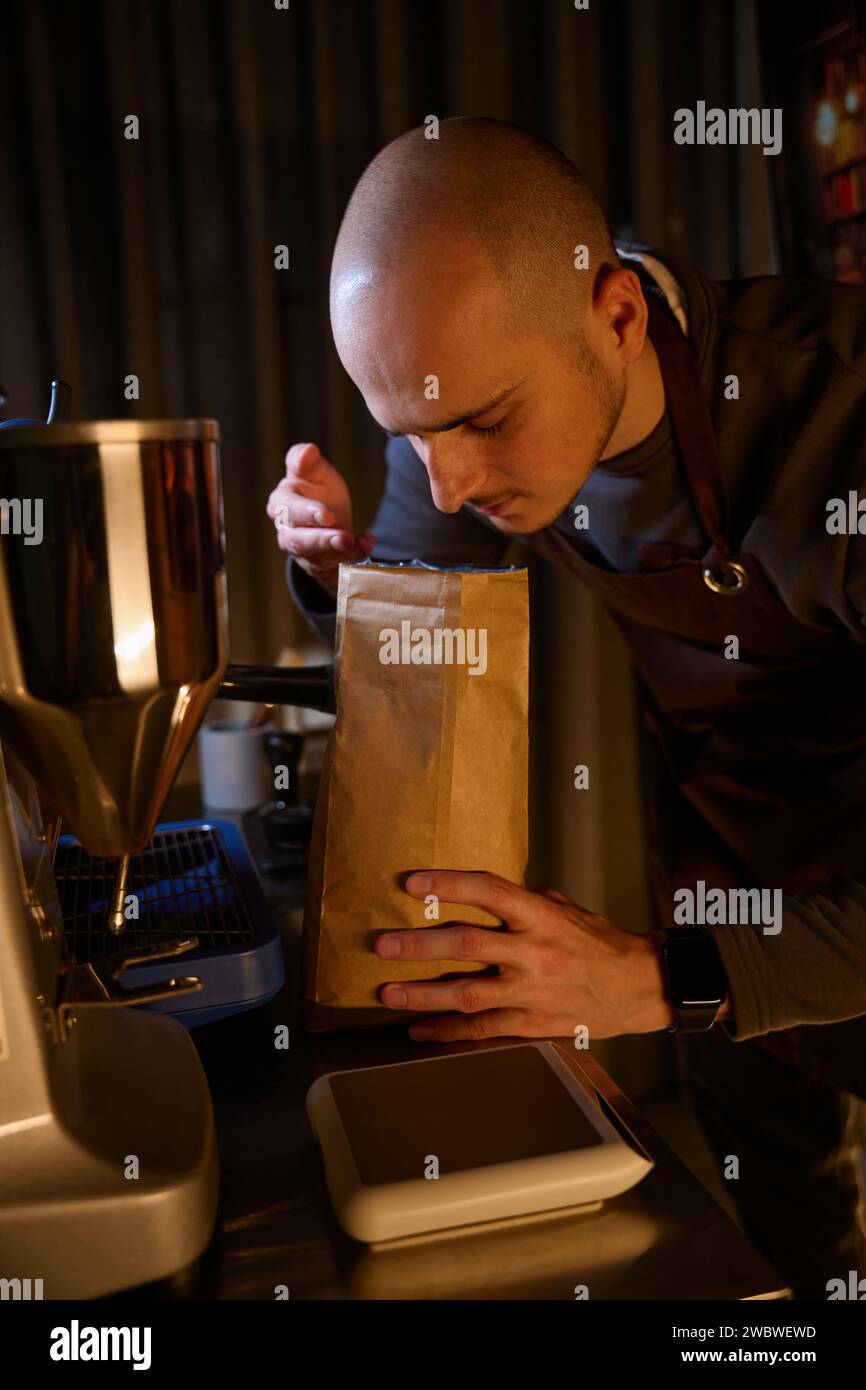 Coffee maker smelling aroma of coffee beans before espresso brewing ...