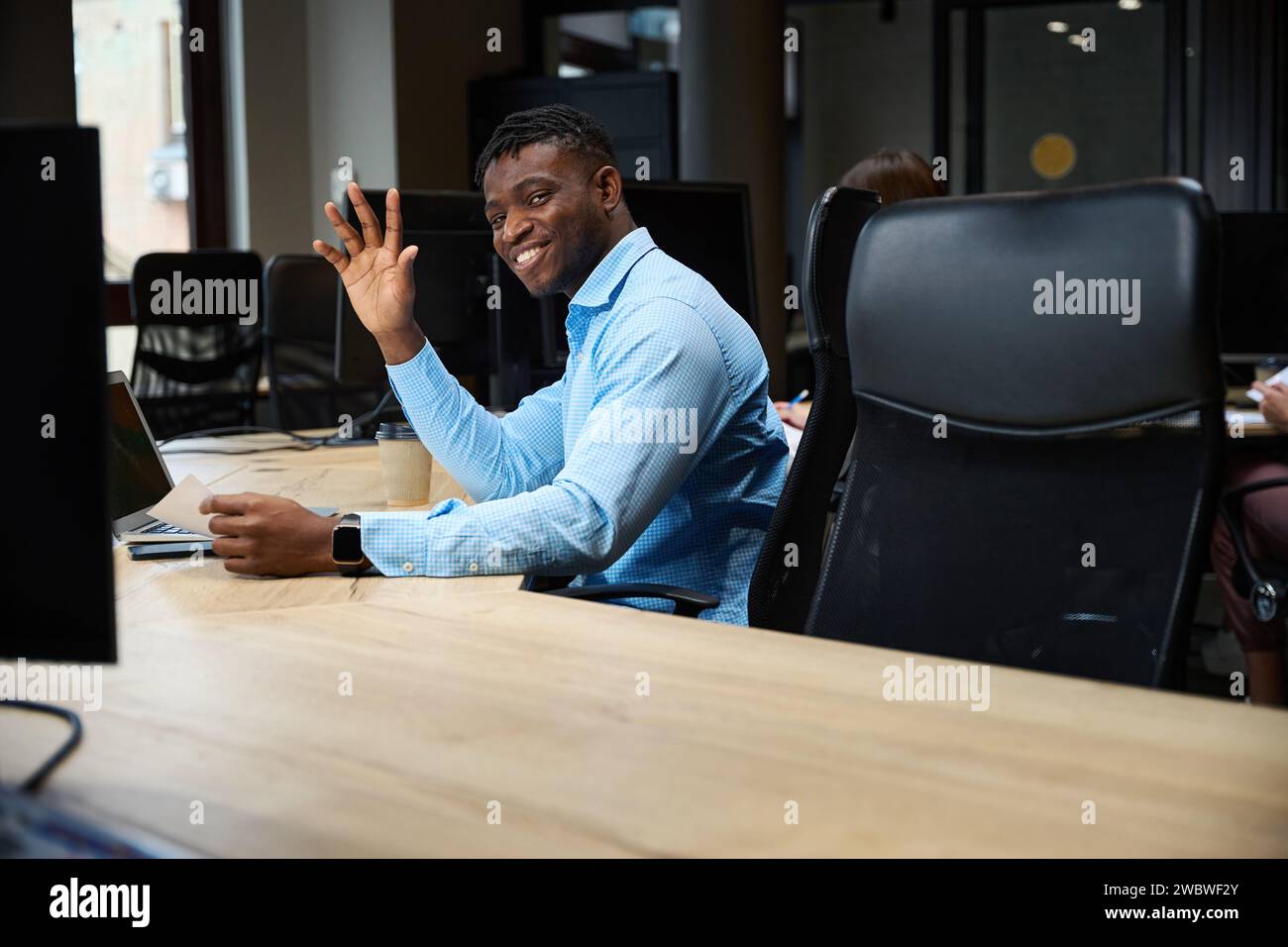 Cheerful African American manager saying hi and smiling Stock Photo - Alamy
