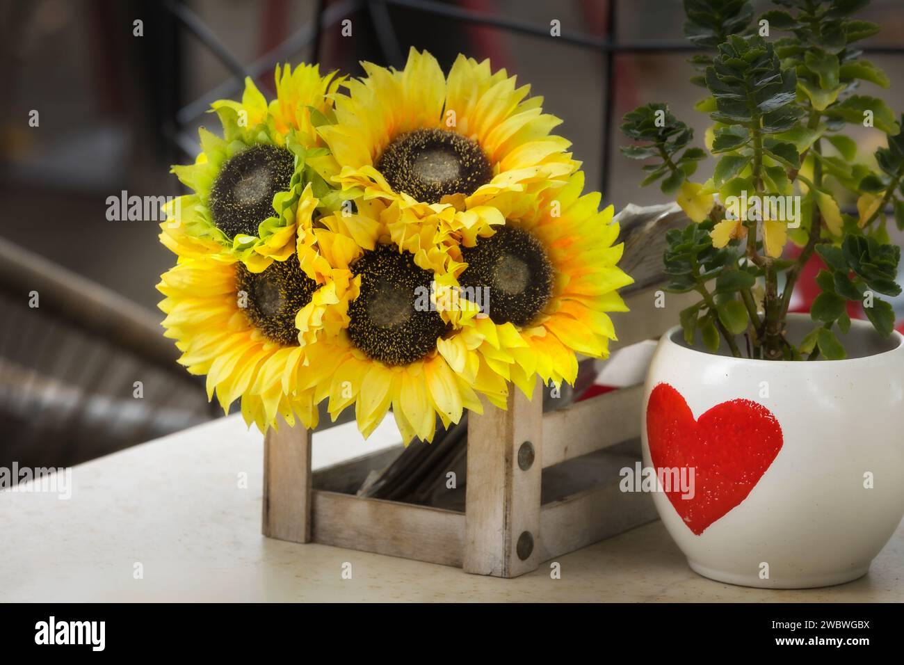 Sunflowers in a floral arrangement and red heart table cafe decoration ...