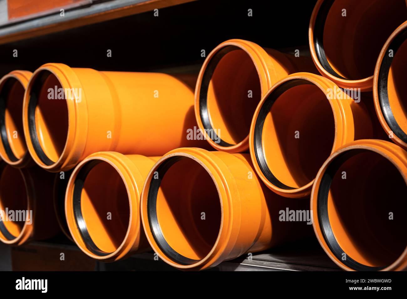 Stack of PVC U canalization pipes on a hardware store. Brown plastic ...