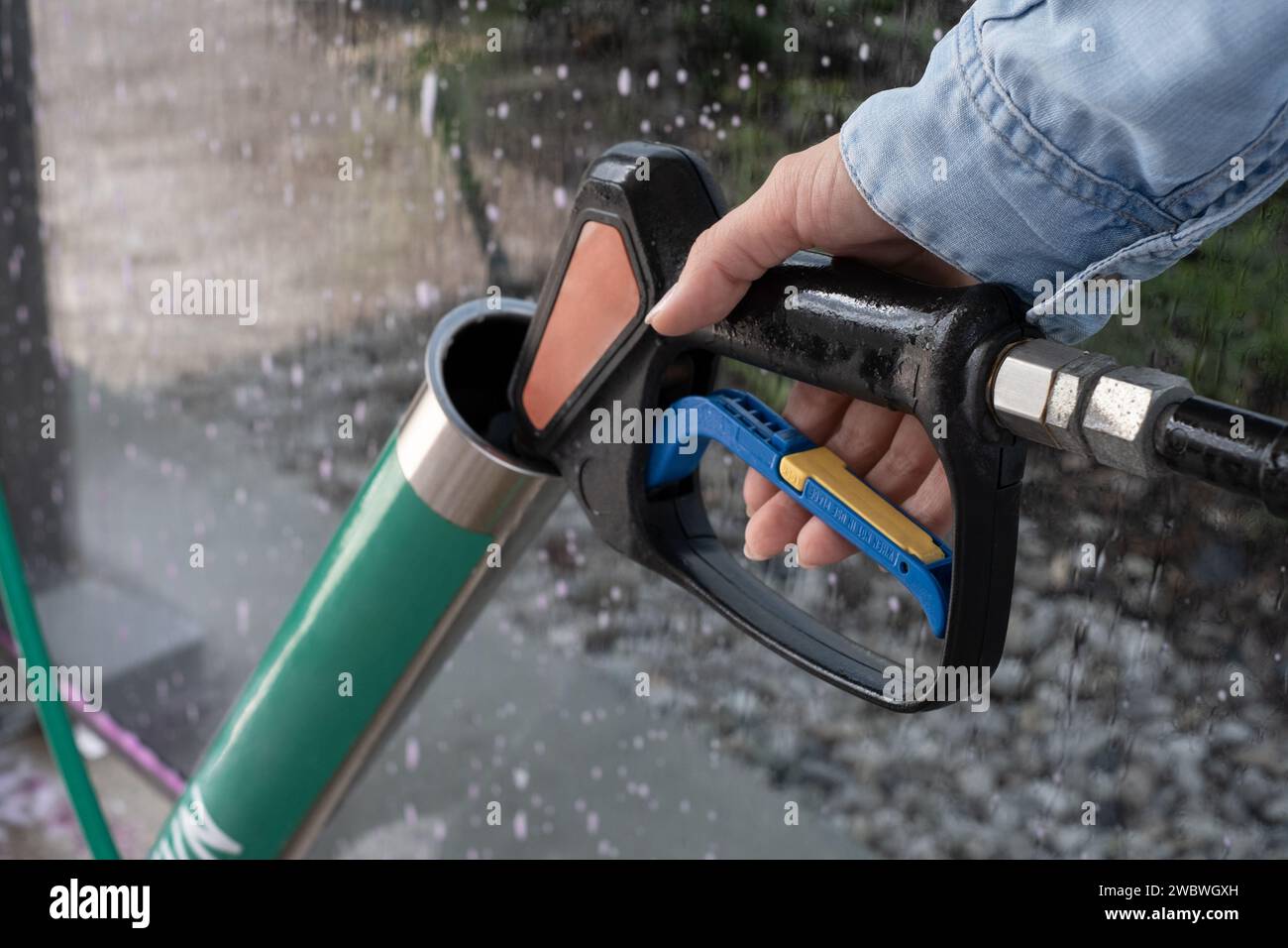 Close-up of a woman's hand taking a contactless car wash foam gun. Foam ...
