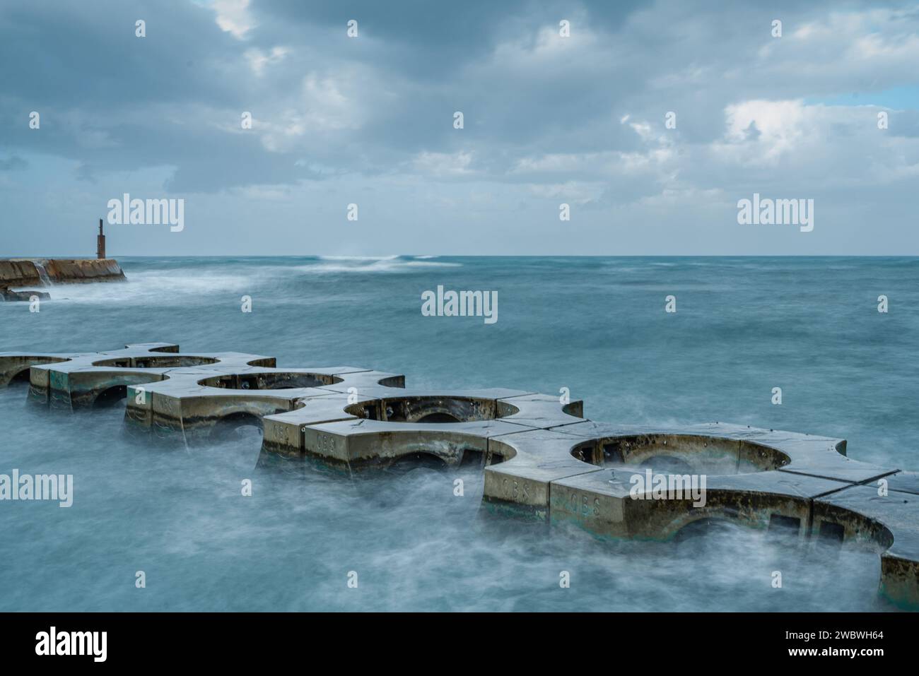 A picturesque breakwall positioned amidst the vastness of the ocean ...