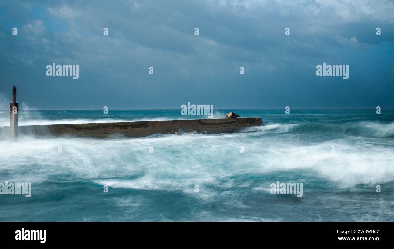 The image captures the powerful force of waves crashing against the ...