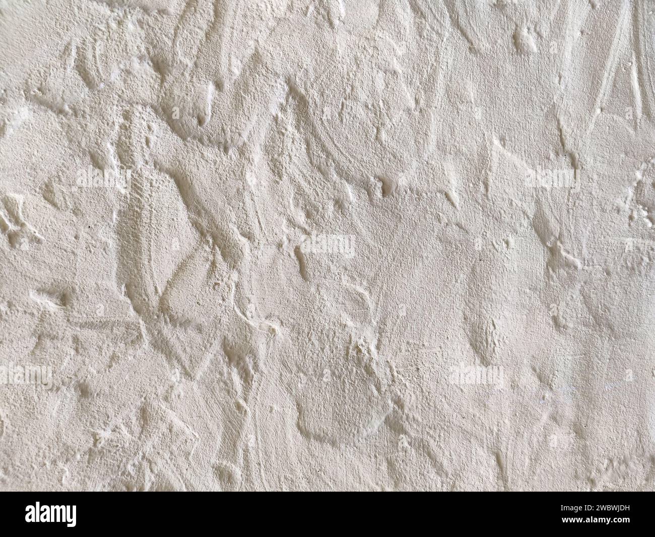 The rough texture of a poorly plastered light-colored wall. An uneven ...