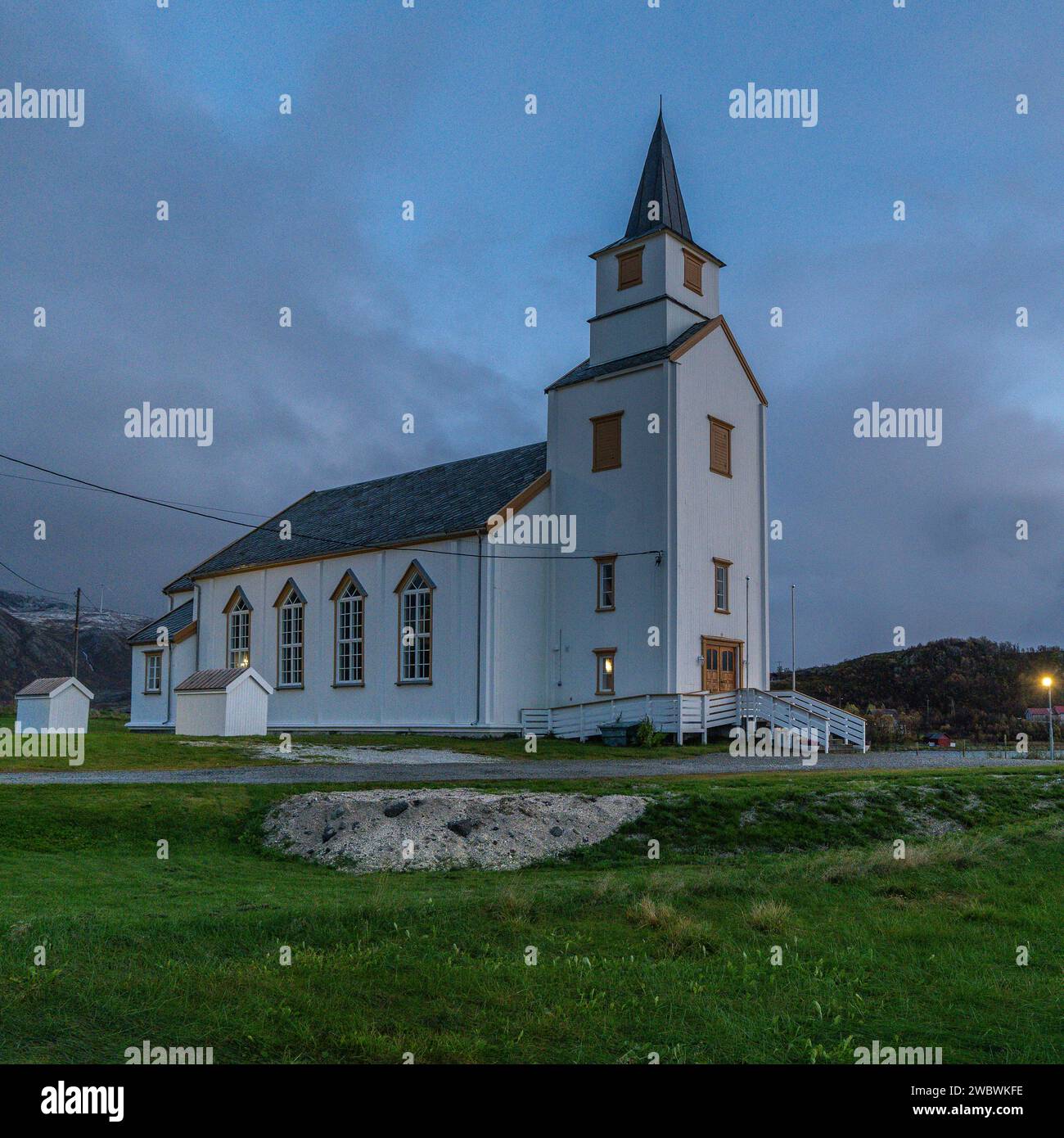 nordic white church in centre of village, with great meadow around ...