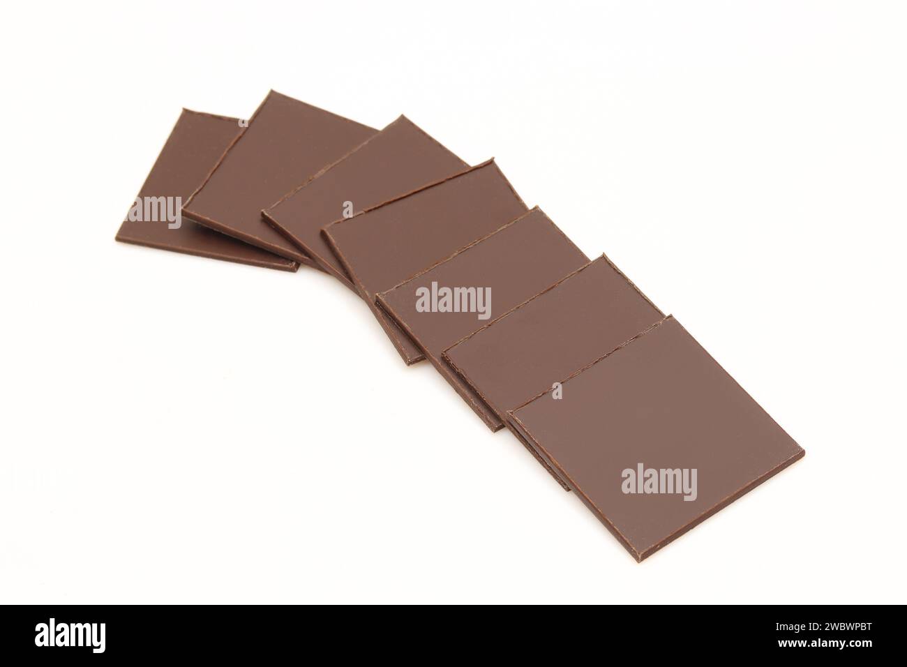 Stack of thin square pieces of chocolate isolated on white background ...