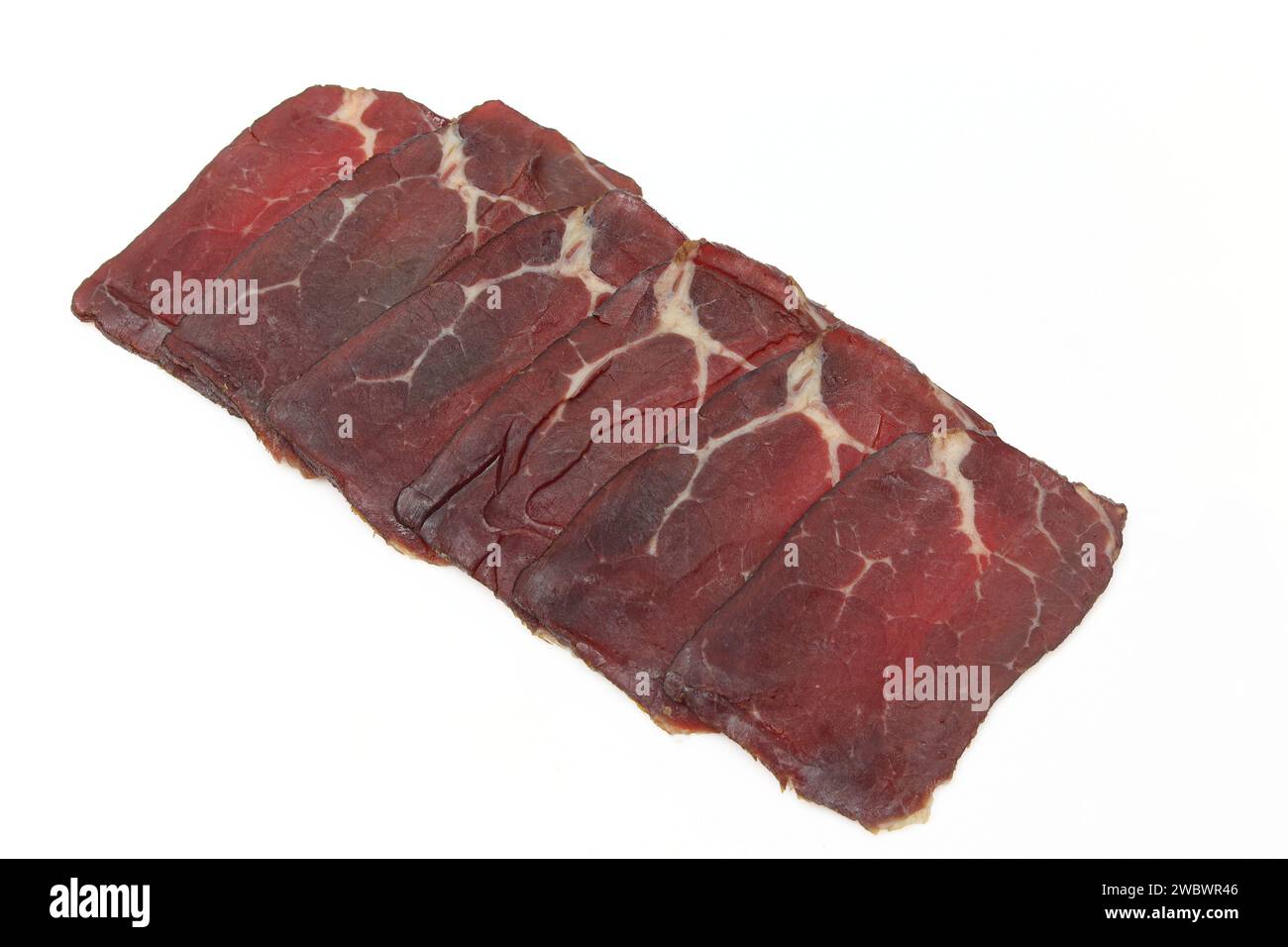 Sliced and served dried beef ham meat isolated on white background ...