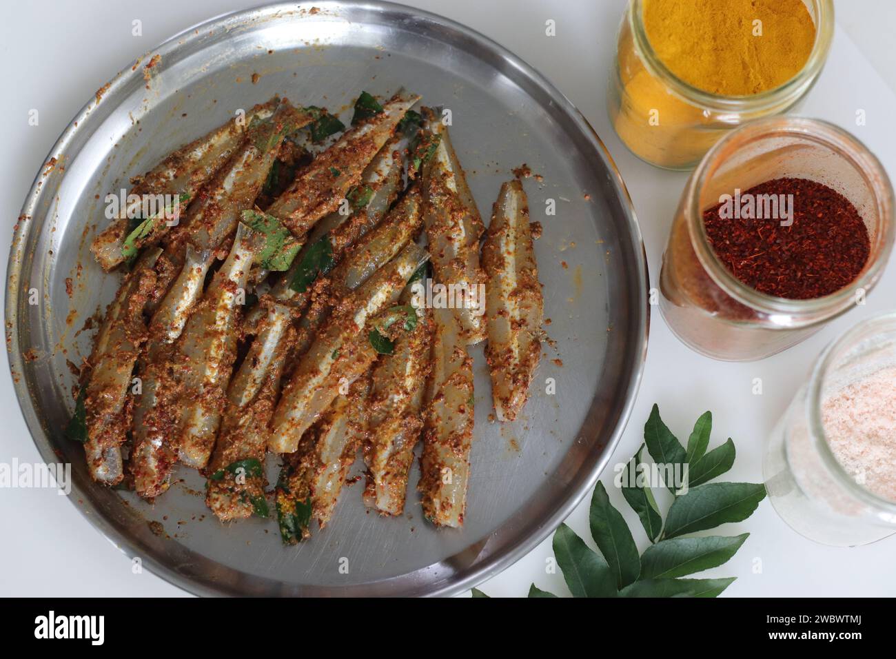 Freshly cut, cleaned and marinated anchovy fish presented on a steel ...