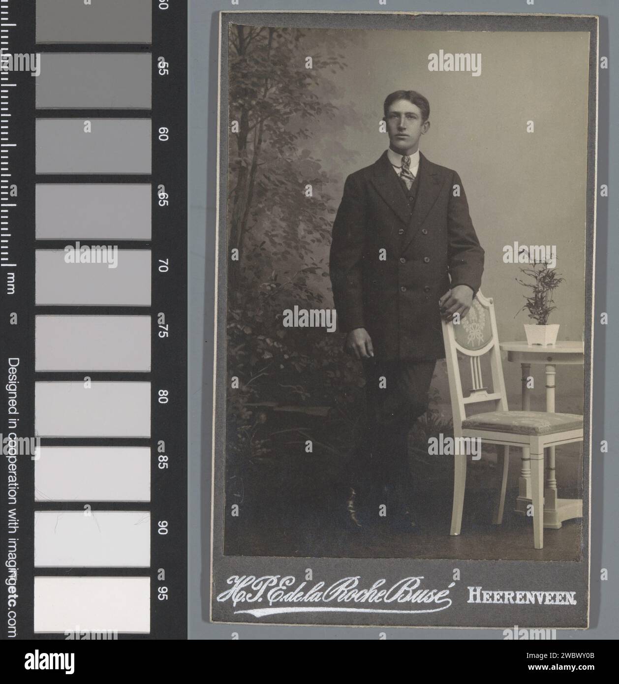 Portrait of an unknown man, standing next to a chair and table, Henri ...