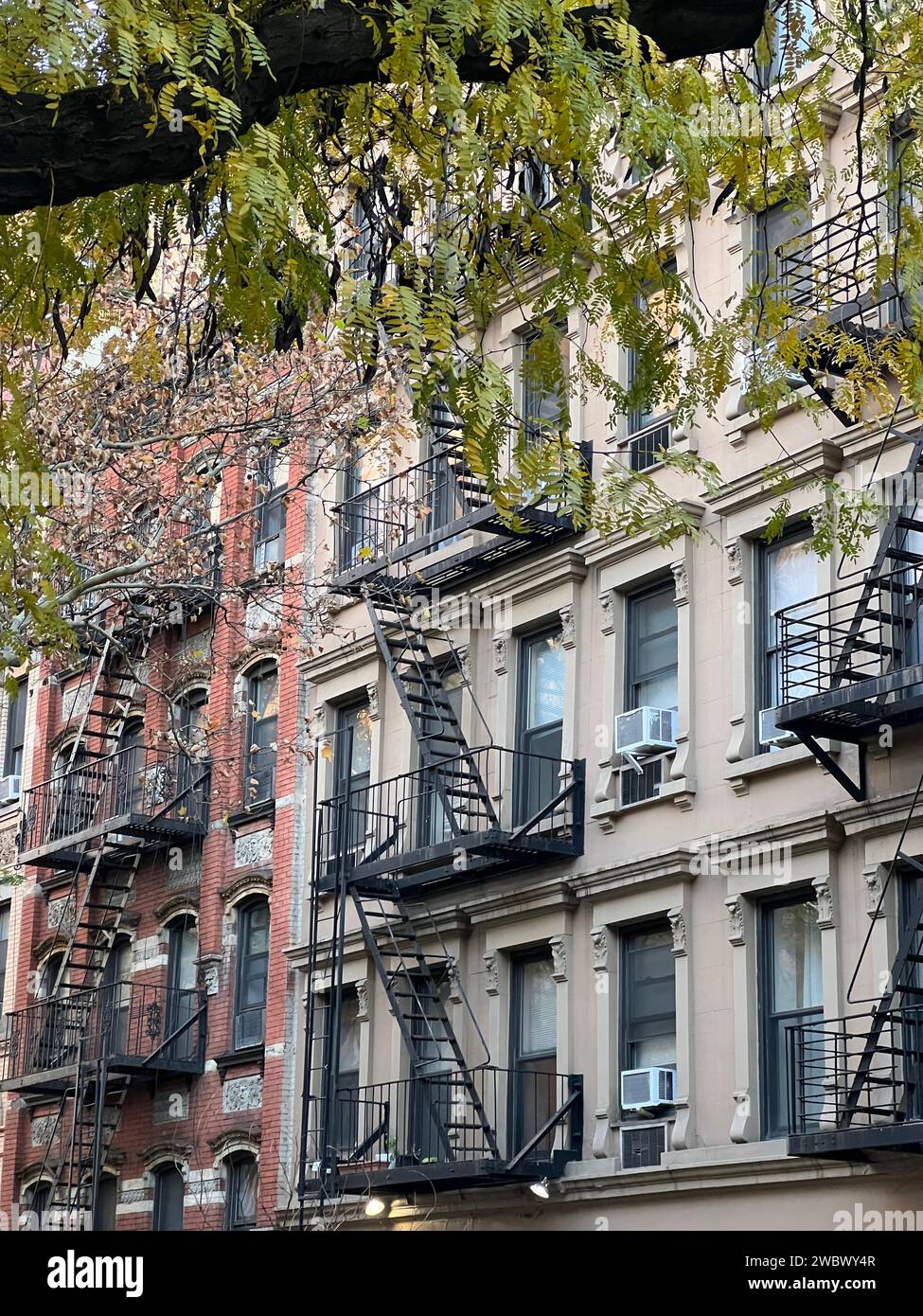 Old colorful buildings with fire ladder and trees on New-york manhattan ...