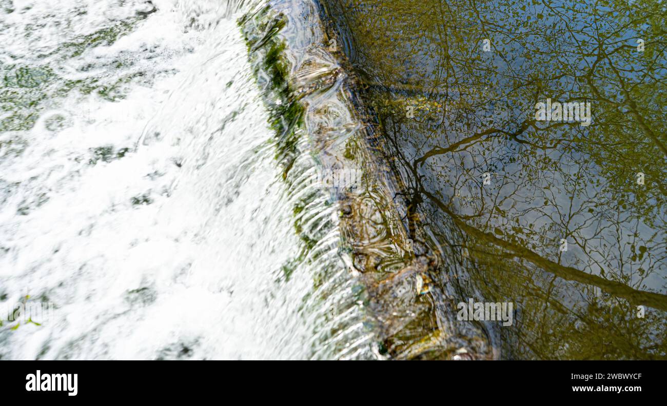 Cascading water over weir showing white foaming water Stock Photo - Alamy