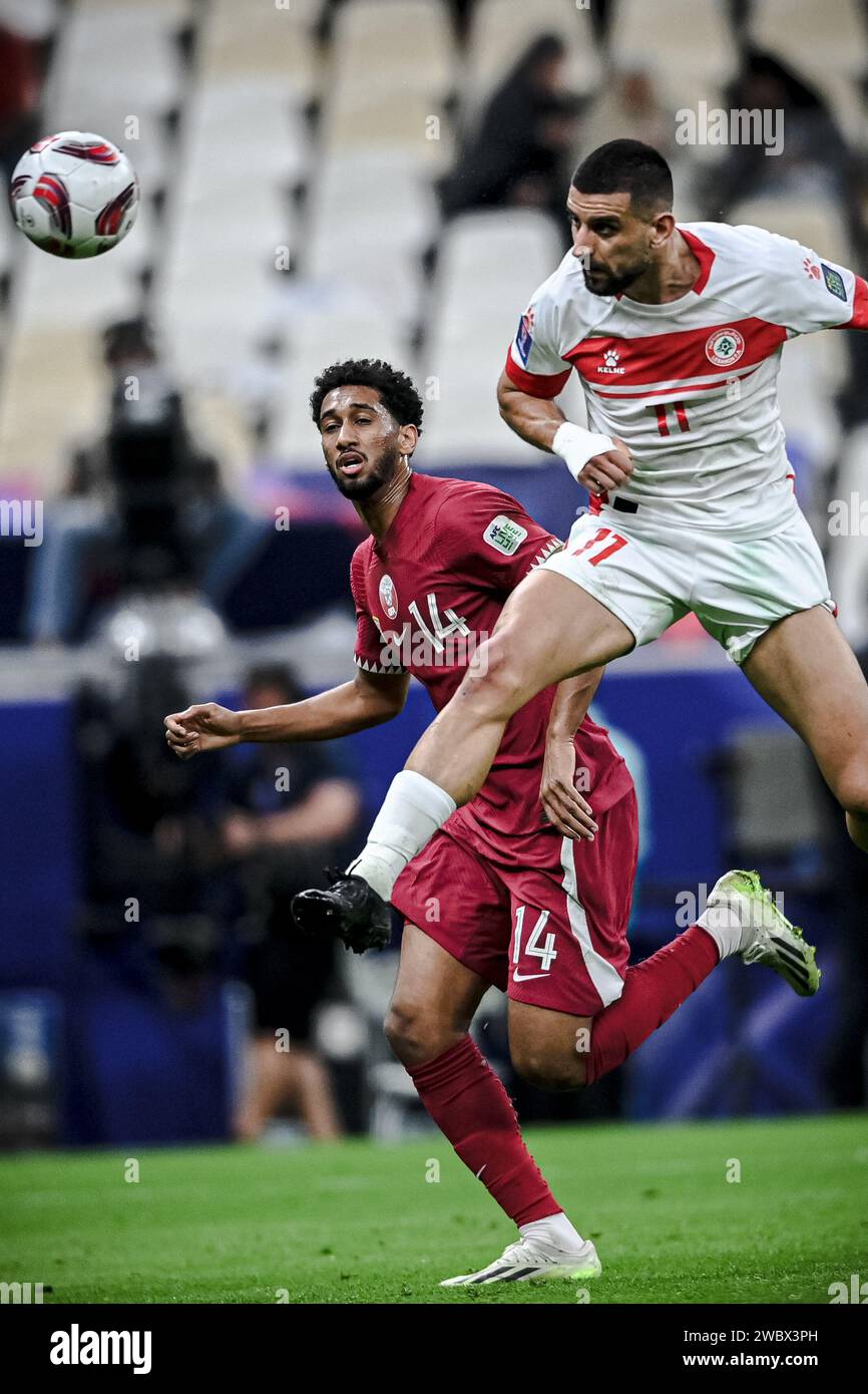Lusail, Qatar. 12th Jan, 2024. Omar Chaaban (R) of Lebanon vies with ...