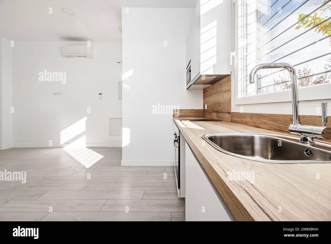 a kitchen under a window with a wooden countertop and backsplashes of ...