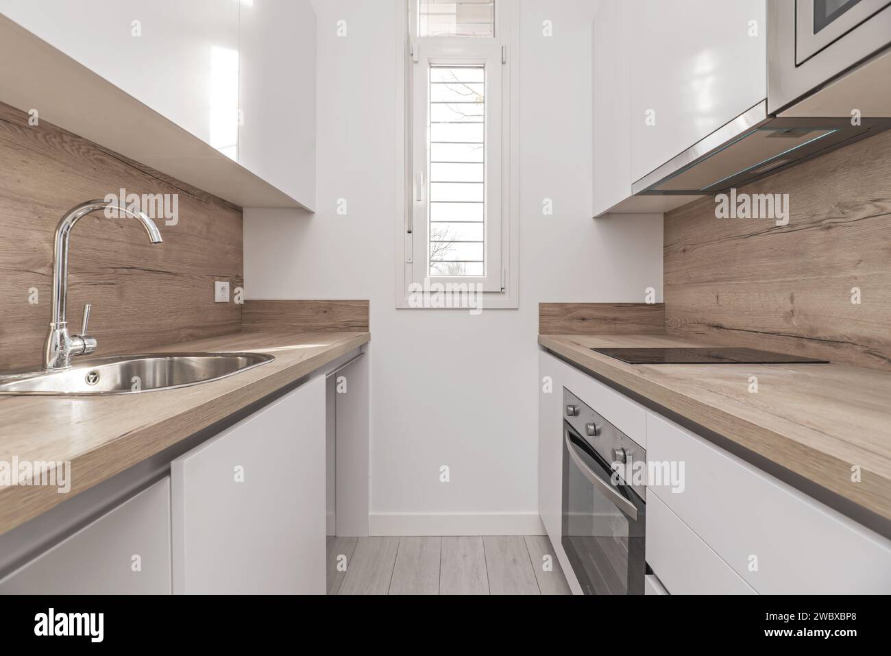 Newly renovated small kitchen with white wooden cabinets, wooden ...