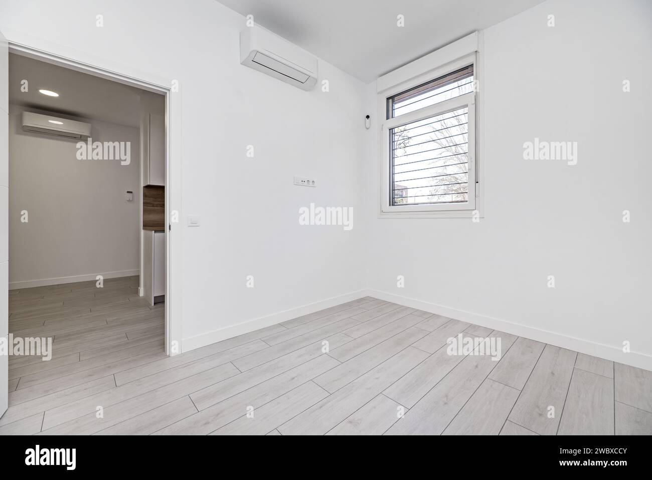 Empty room with light floors, access door to other rooms and aluminum ...