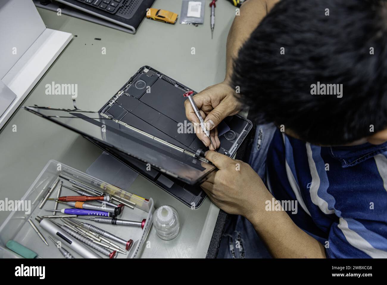 An electronic repair shop operator disassembling a tablet Stock Photo ...