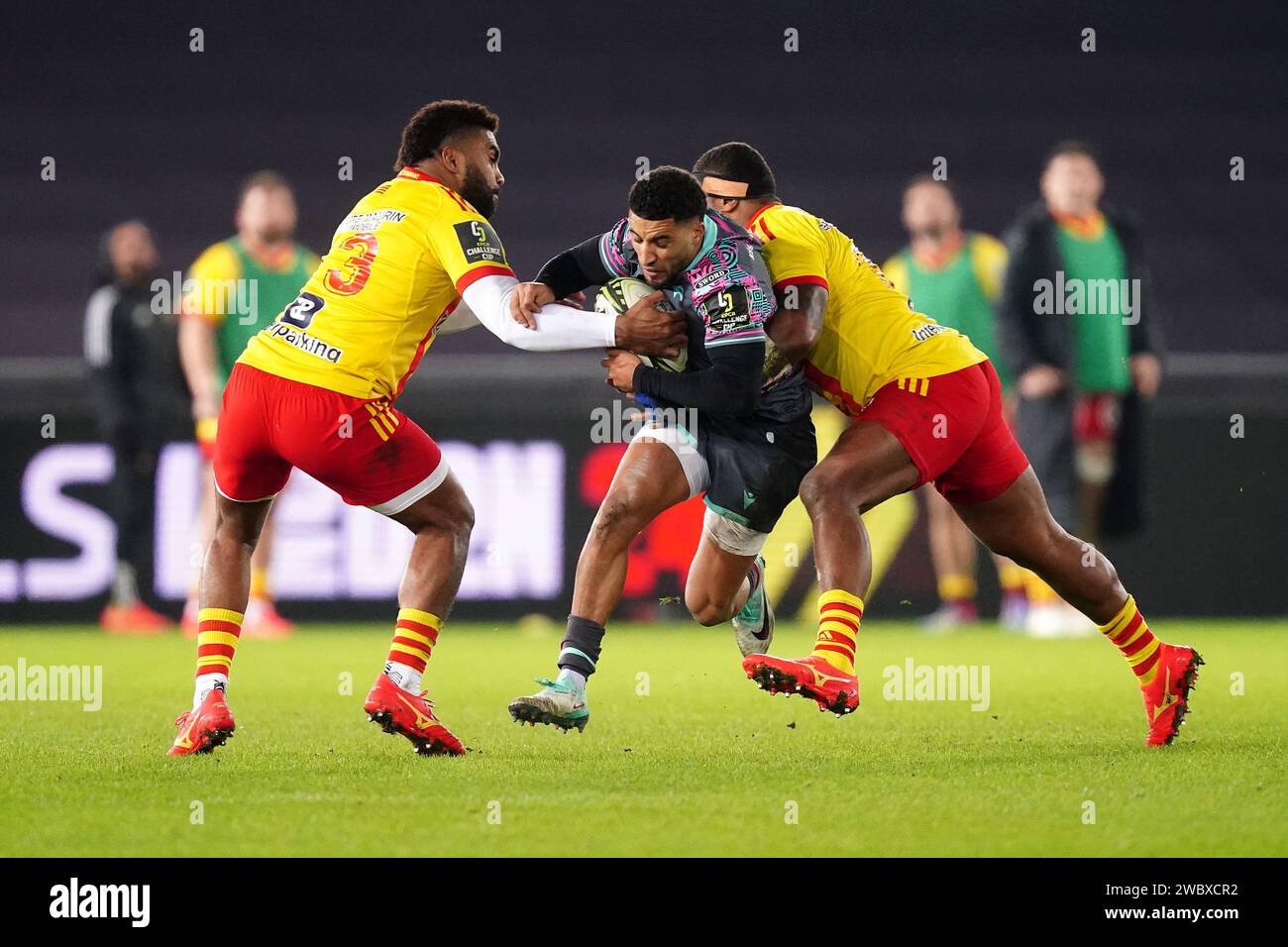 Ospreys' Keelan Giles (centre) tackled by USA Perpignan's Edward ...
