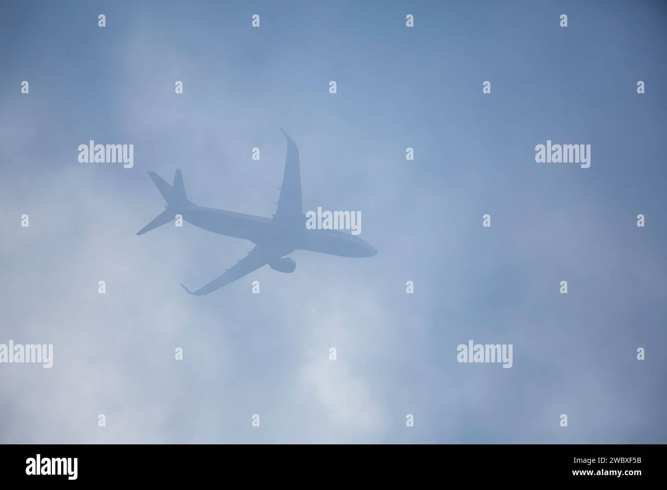 Passenger plane passing through the clouds Stock Photo - Alamy