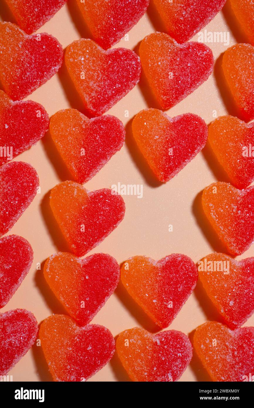 Array of heart-shaped orange and red gummies, one of them is missing ...