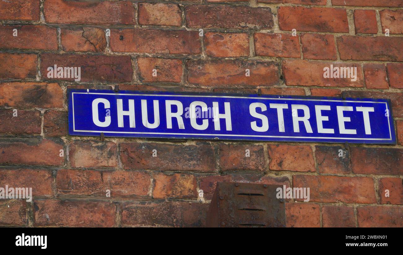 Street name sign: Blue wall plaque on a red brick wall with Church ...