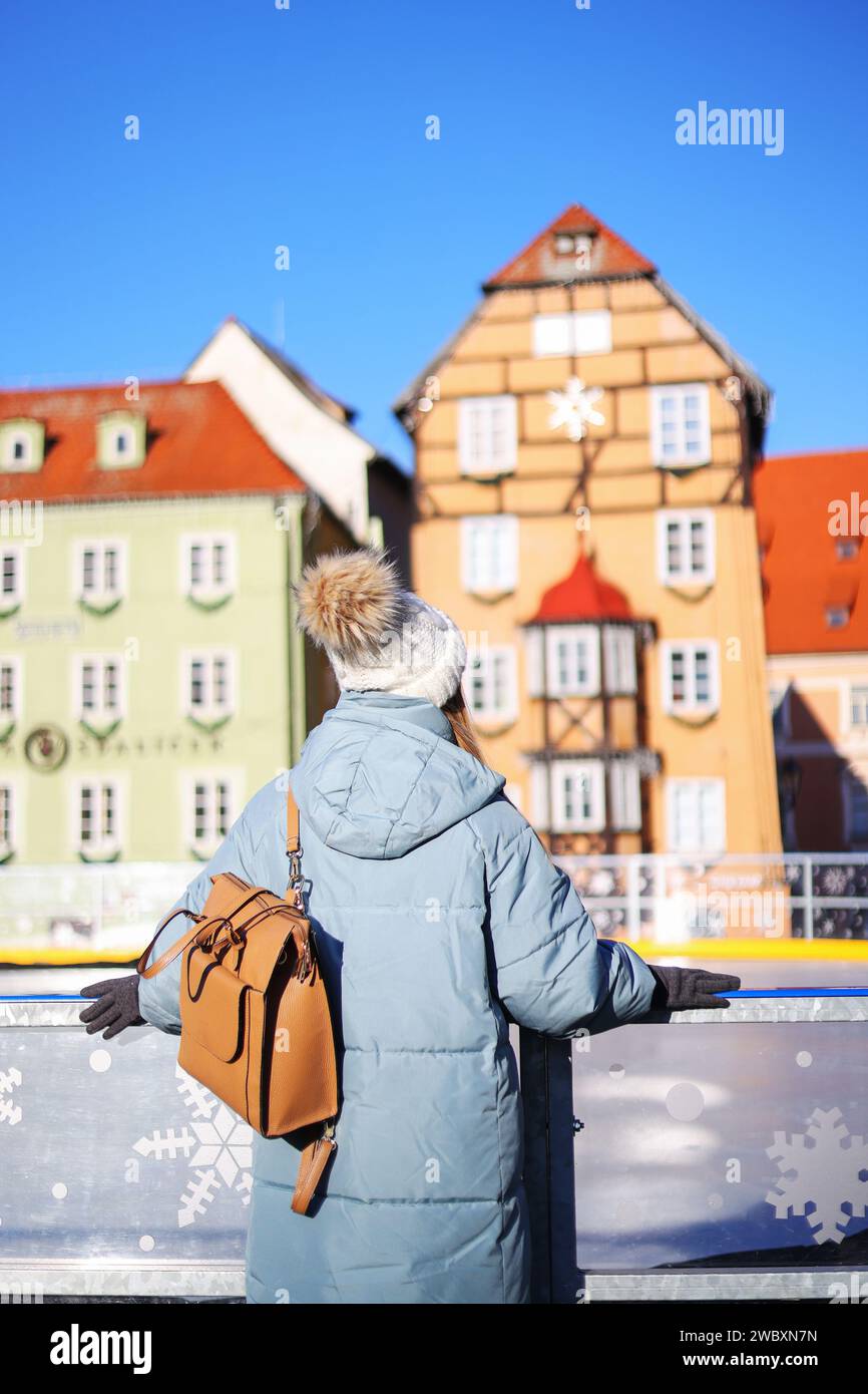 Beautiful girl stay back at ice rink. Enjoying nature, winter time in ...