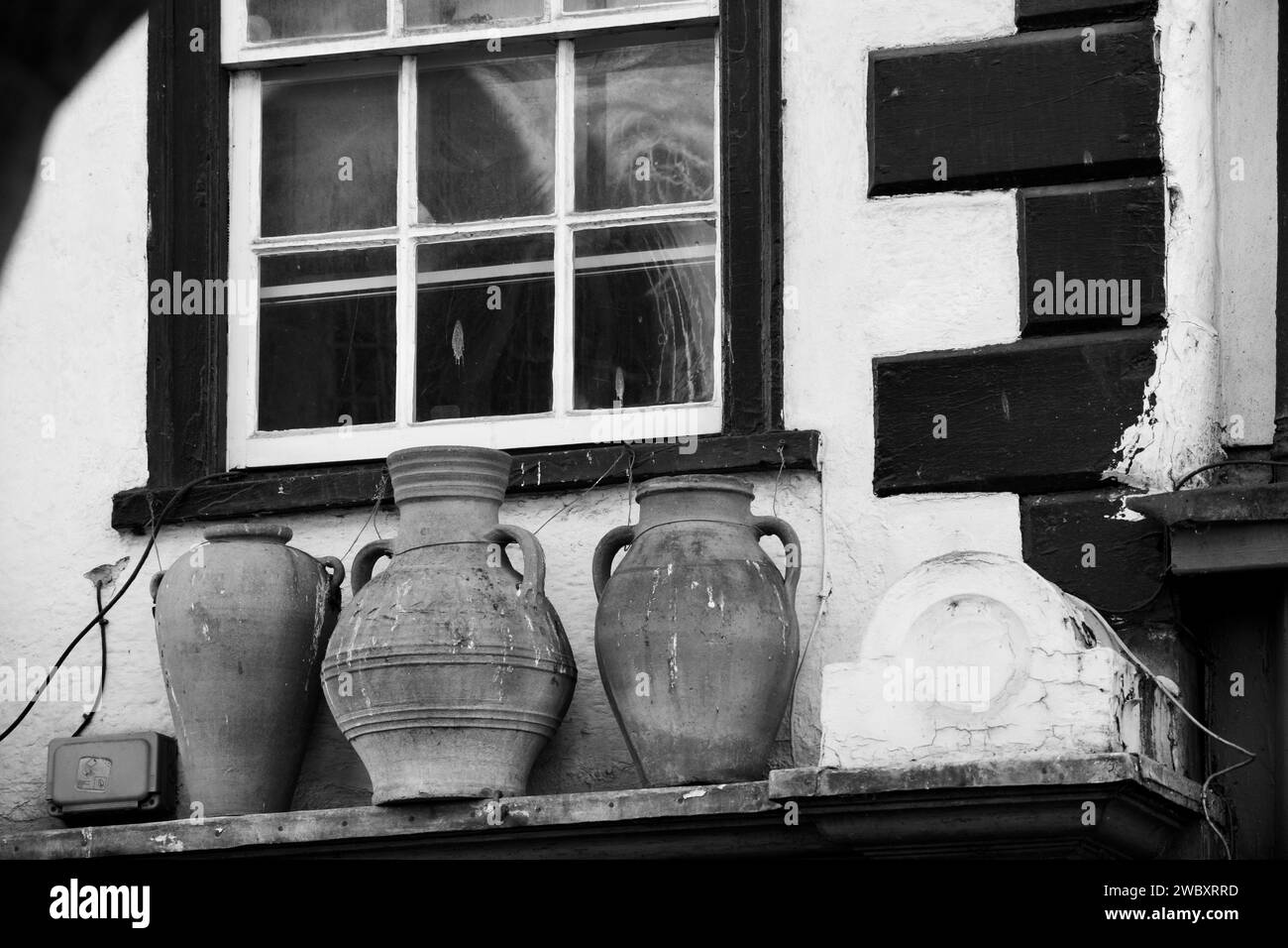 Old clay pots arranged on a shelf outside a window in Ross on Wye ...