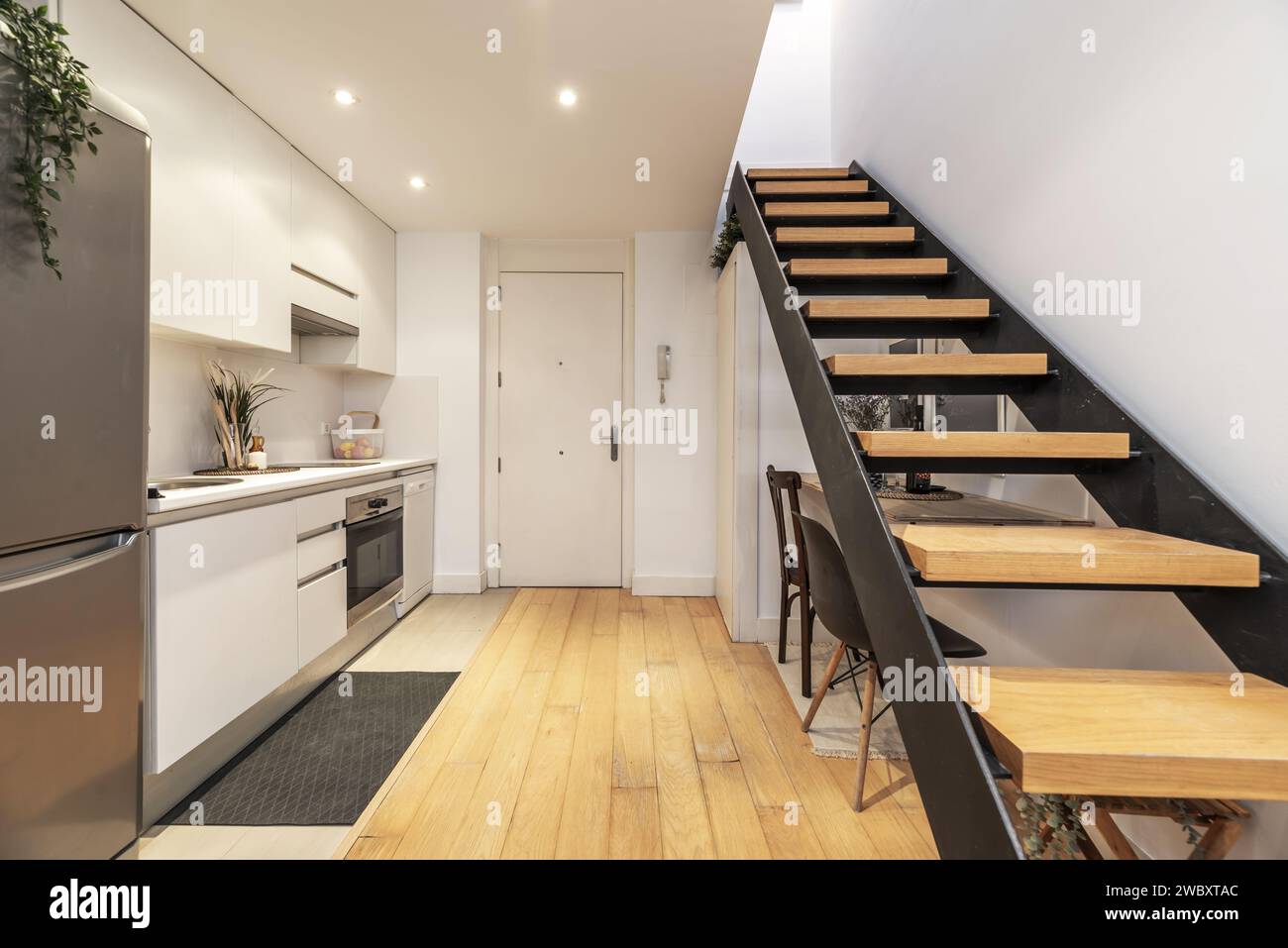 small loft-type house with wooden and metal stairs to access the second ...