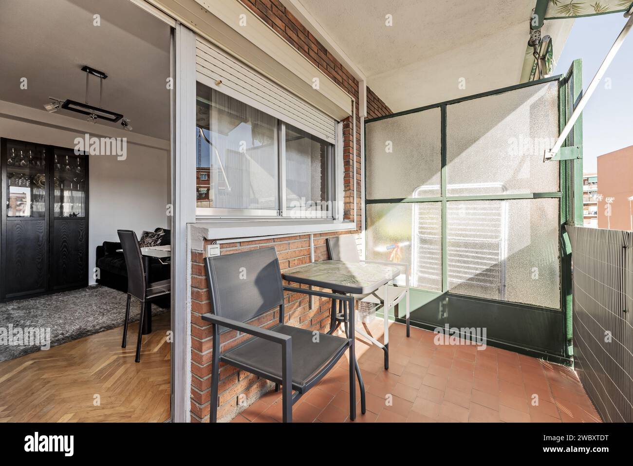 A small terrace with some furniture with table and chairs, a separating ...